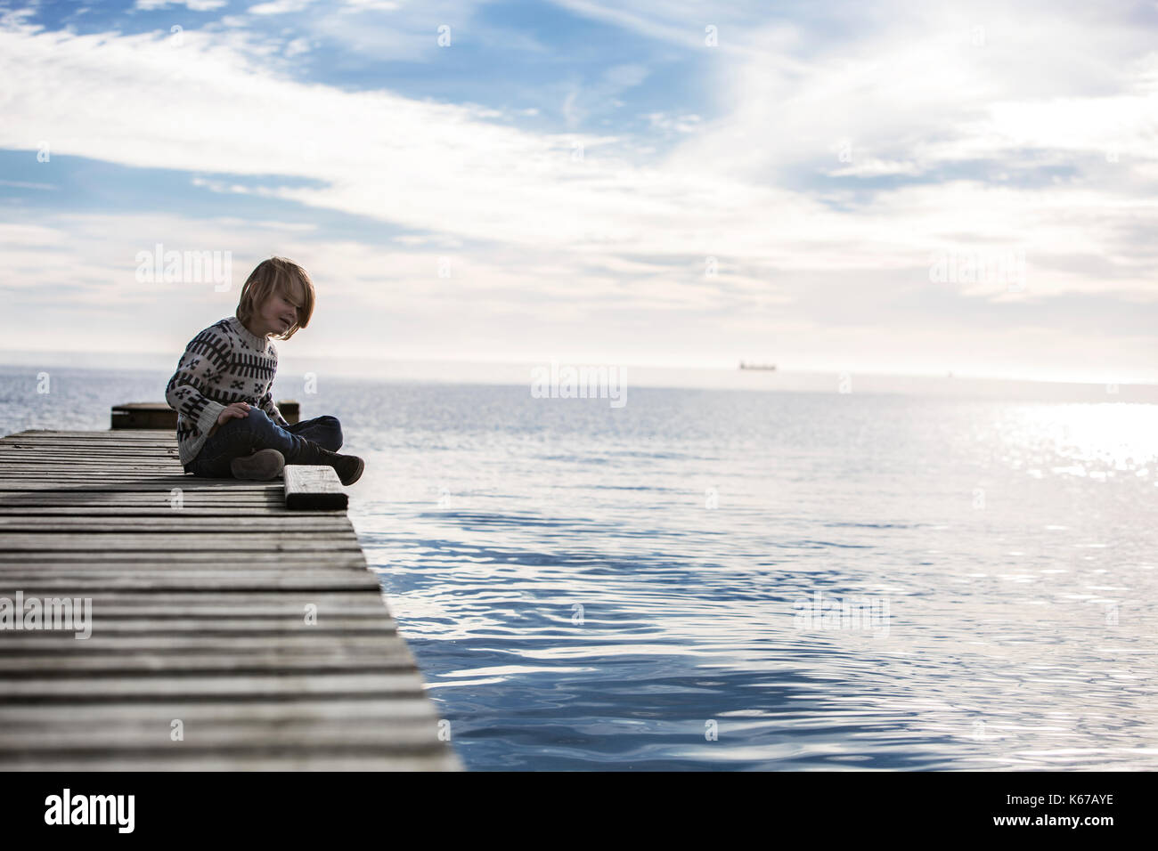 Children sitting on pier hi-res stock photography and images - Alamy