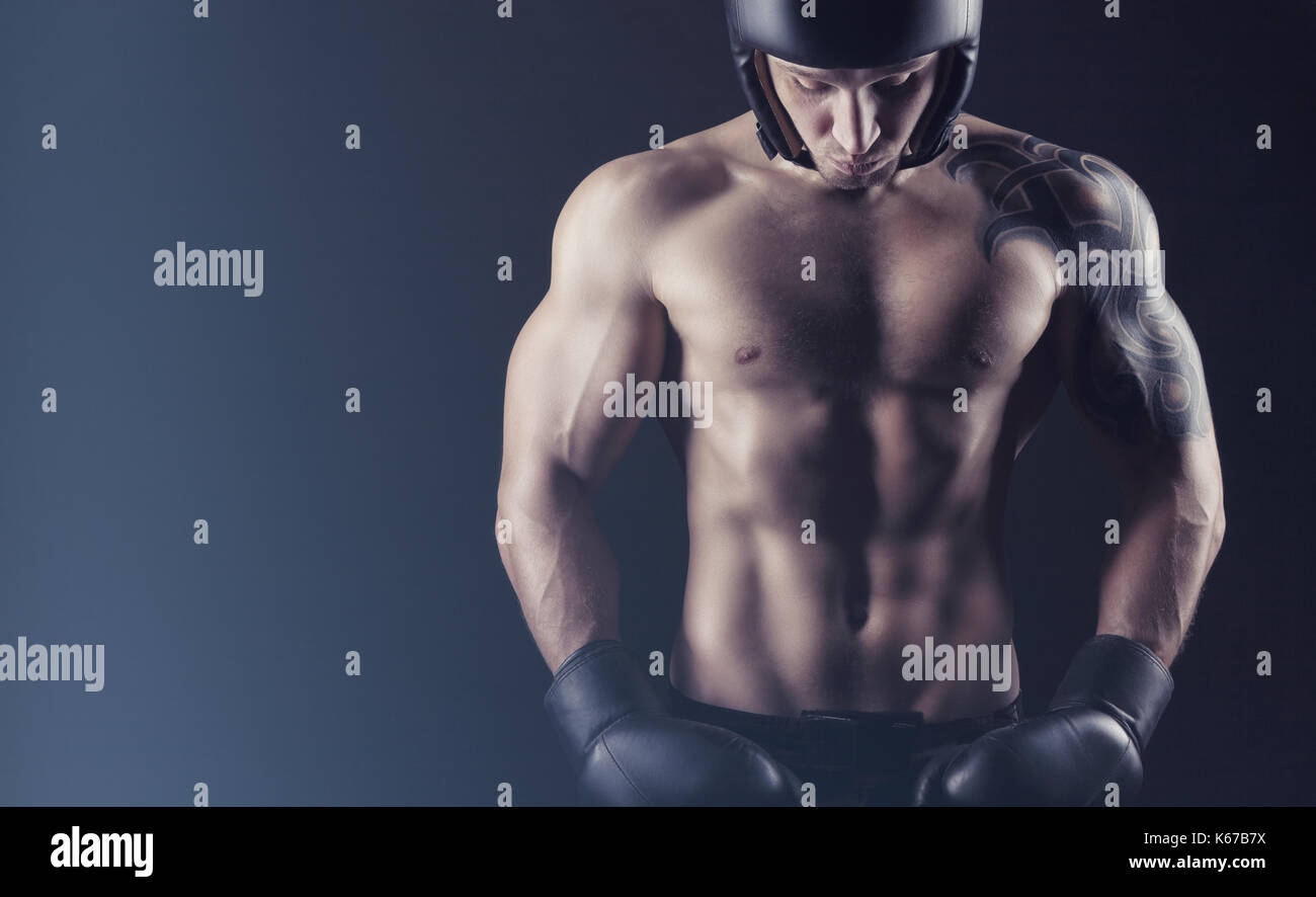 Boxer with boxing gloves before a fight against a black background ...