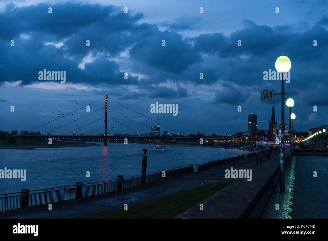 View of the promenade and the Oberkassel bridge at night in Dusseldorf ...