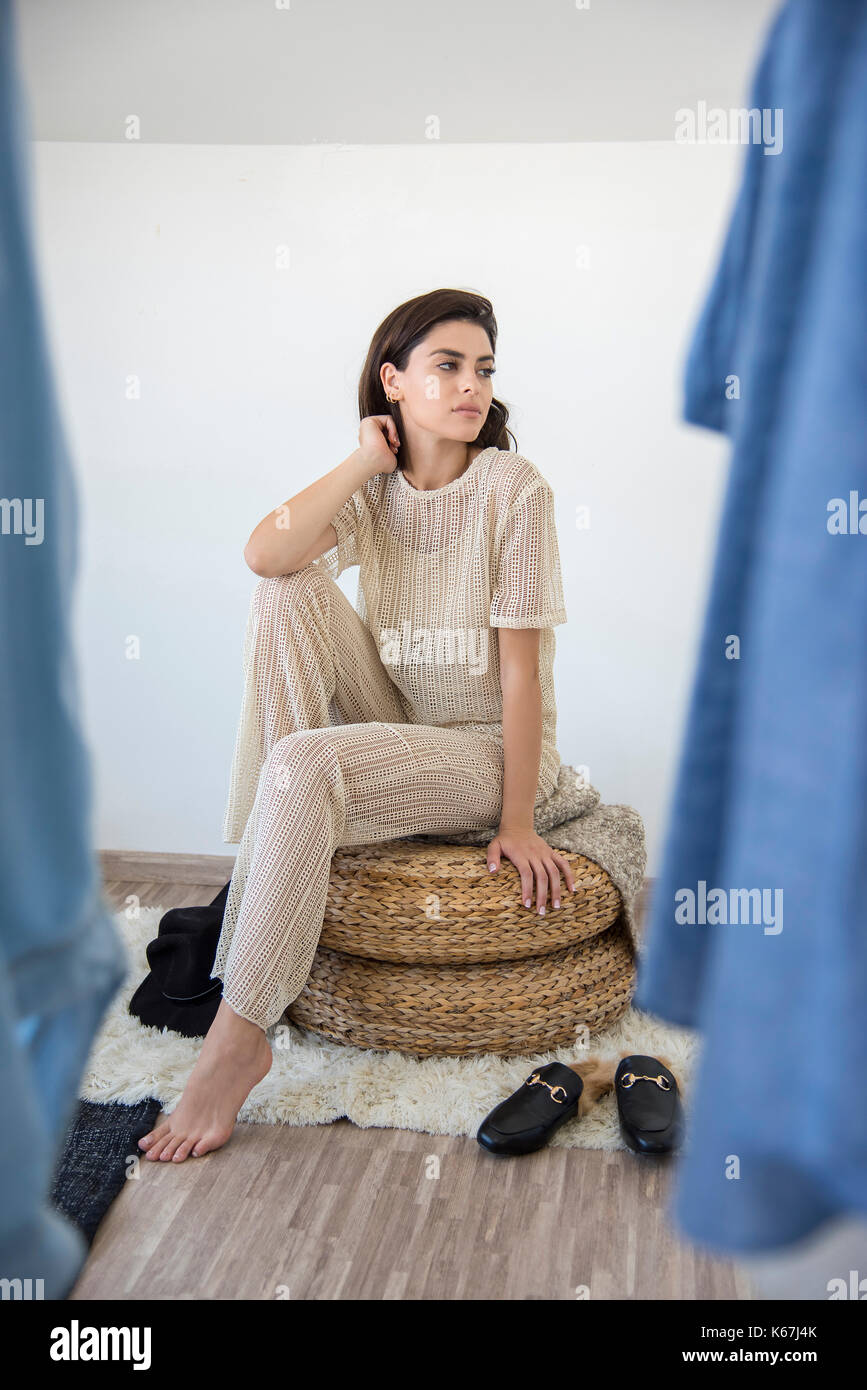 Young woman sitting alone in a pouf in her room Stock Photo - Alamy
