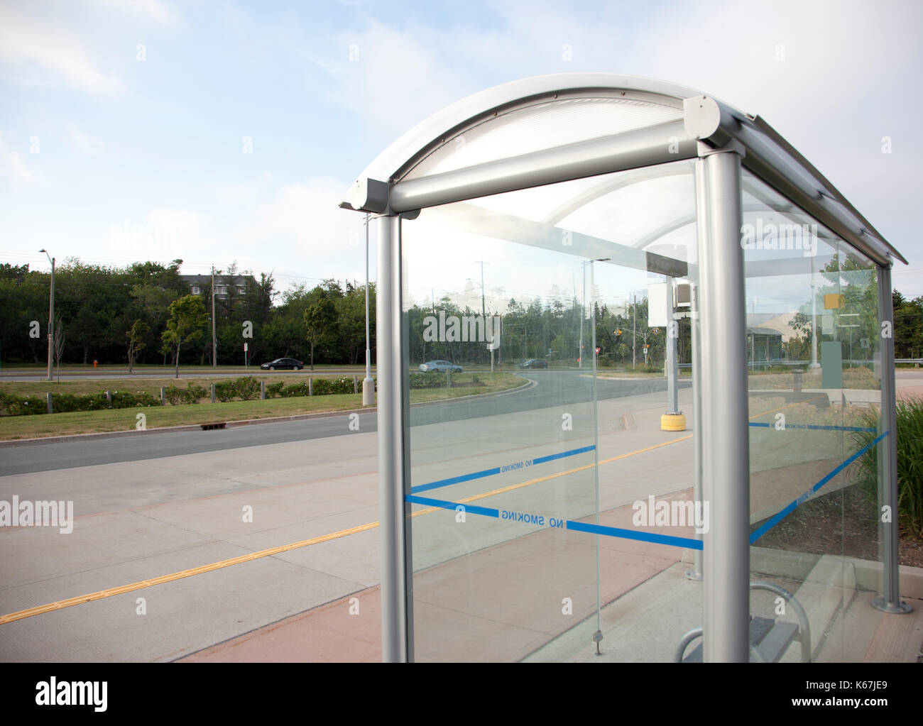a glass bus stop is empty during daytime Stock Photo - Alamy