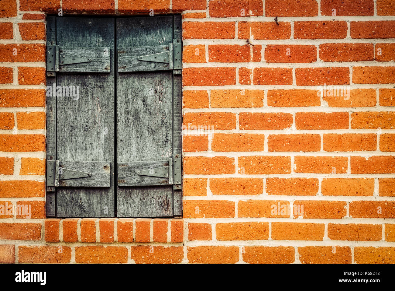 A red brick wall and worn wooden shutters in an old San Diego ...