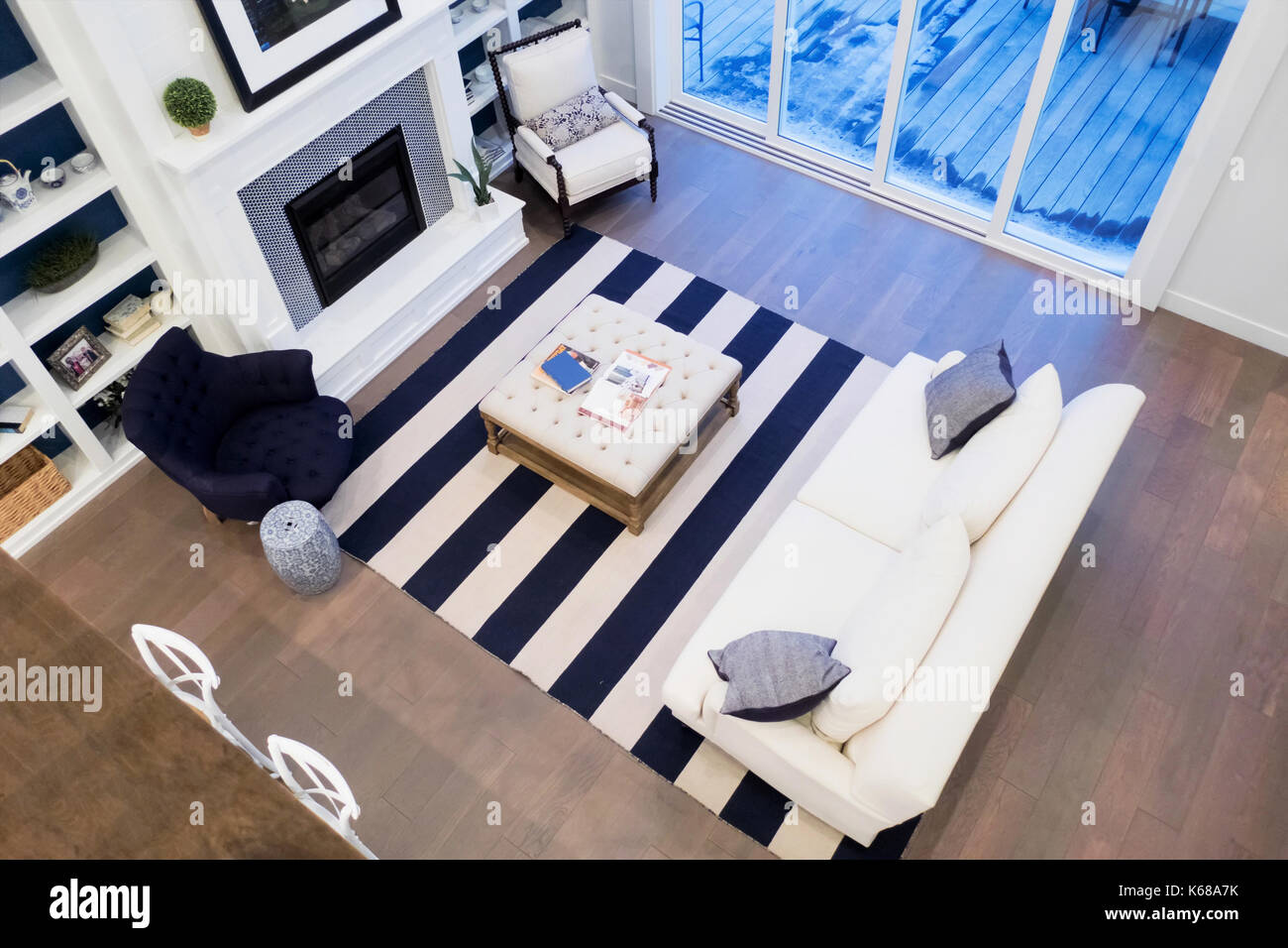 An overhead view of a living room with a white couch, fireplace ...