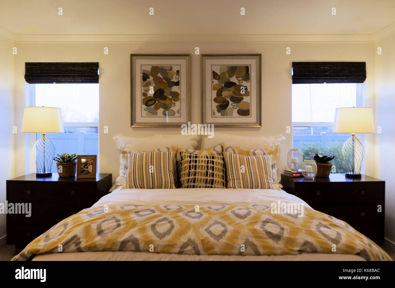 A master bedroom with a yellow checkered comforter and opposite windows ...