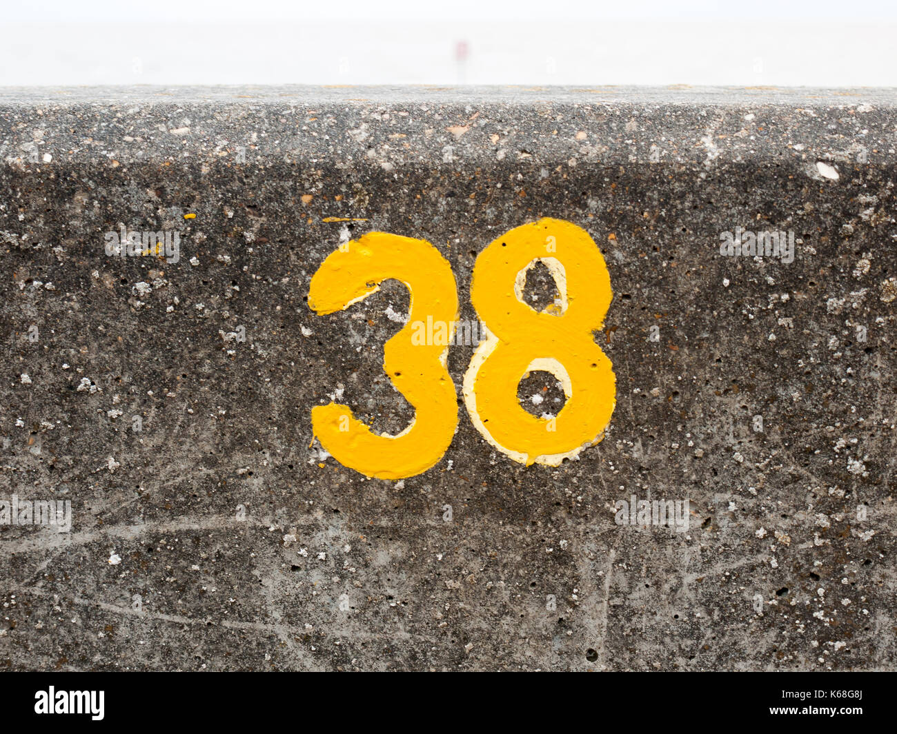 a yellow numbering with paint on sea front wall Harwich 38; England; UK ...