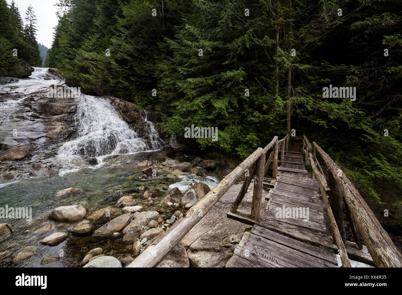 Wooden bridge over a flowing river on a hiking trail. Picture taken on ...