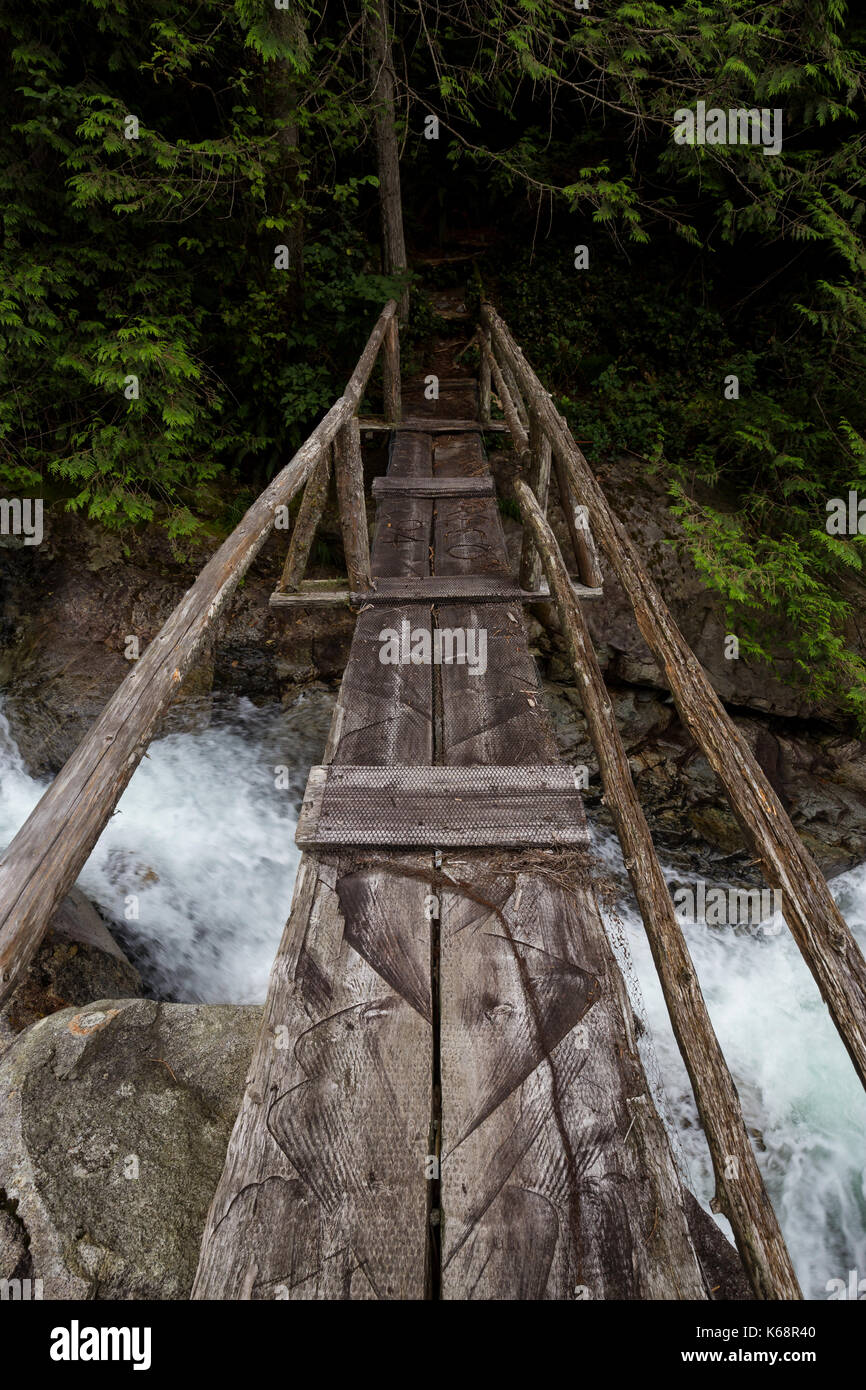 Wooden bridge over a flowing river on a hiking trail. Picture taken on ...