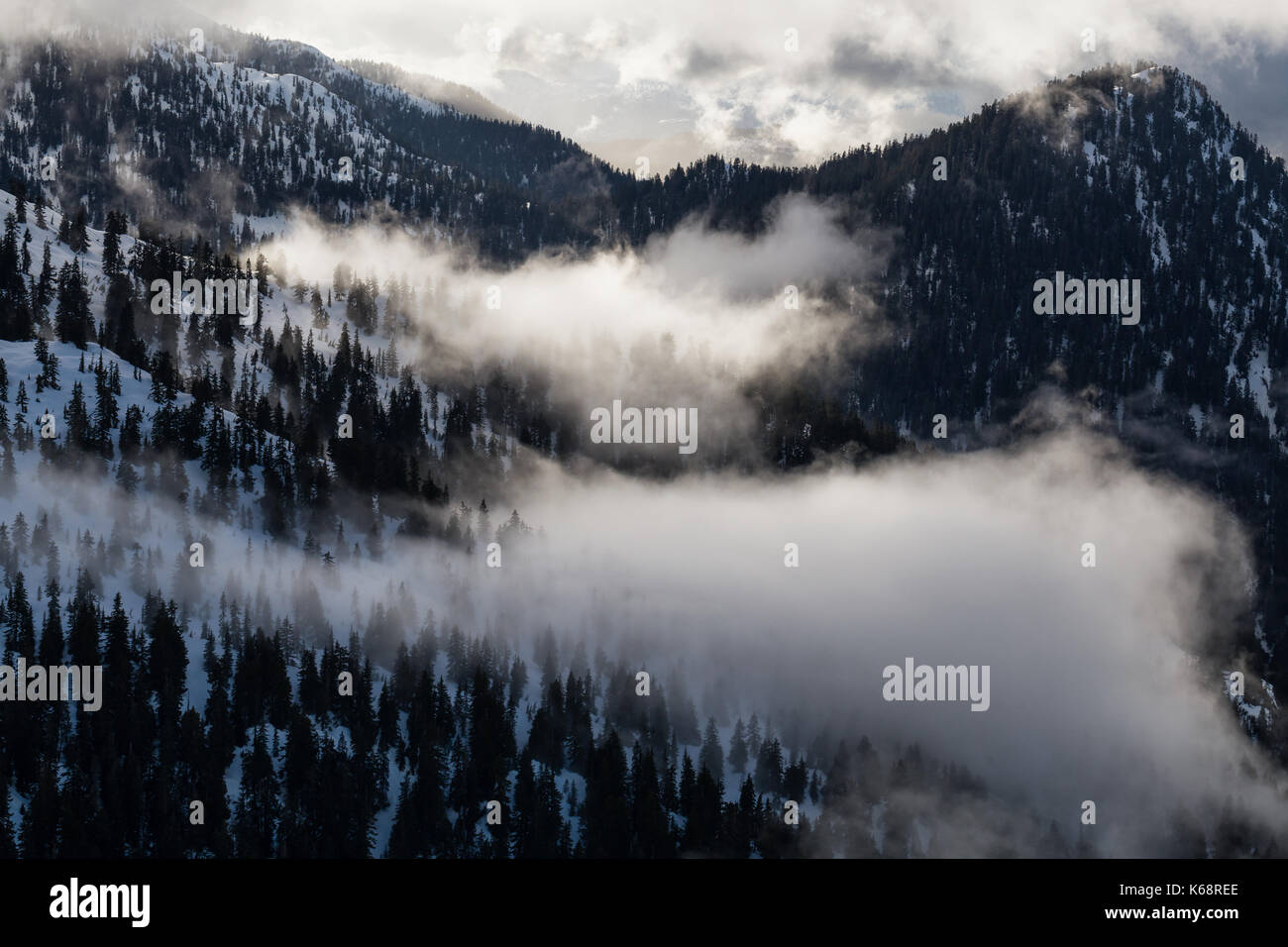 Aerial landscape view of the snow and cloud covered mountain range ...