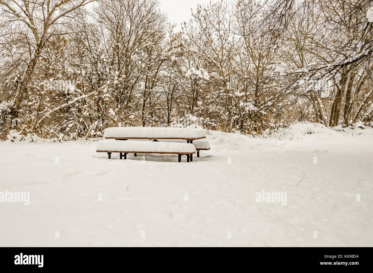 Picnic table covered with ten to twelve inches of snow in a winter ...