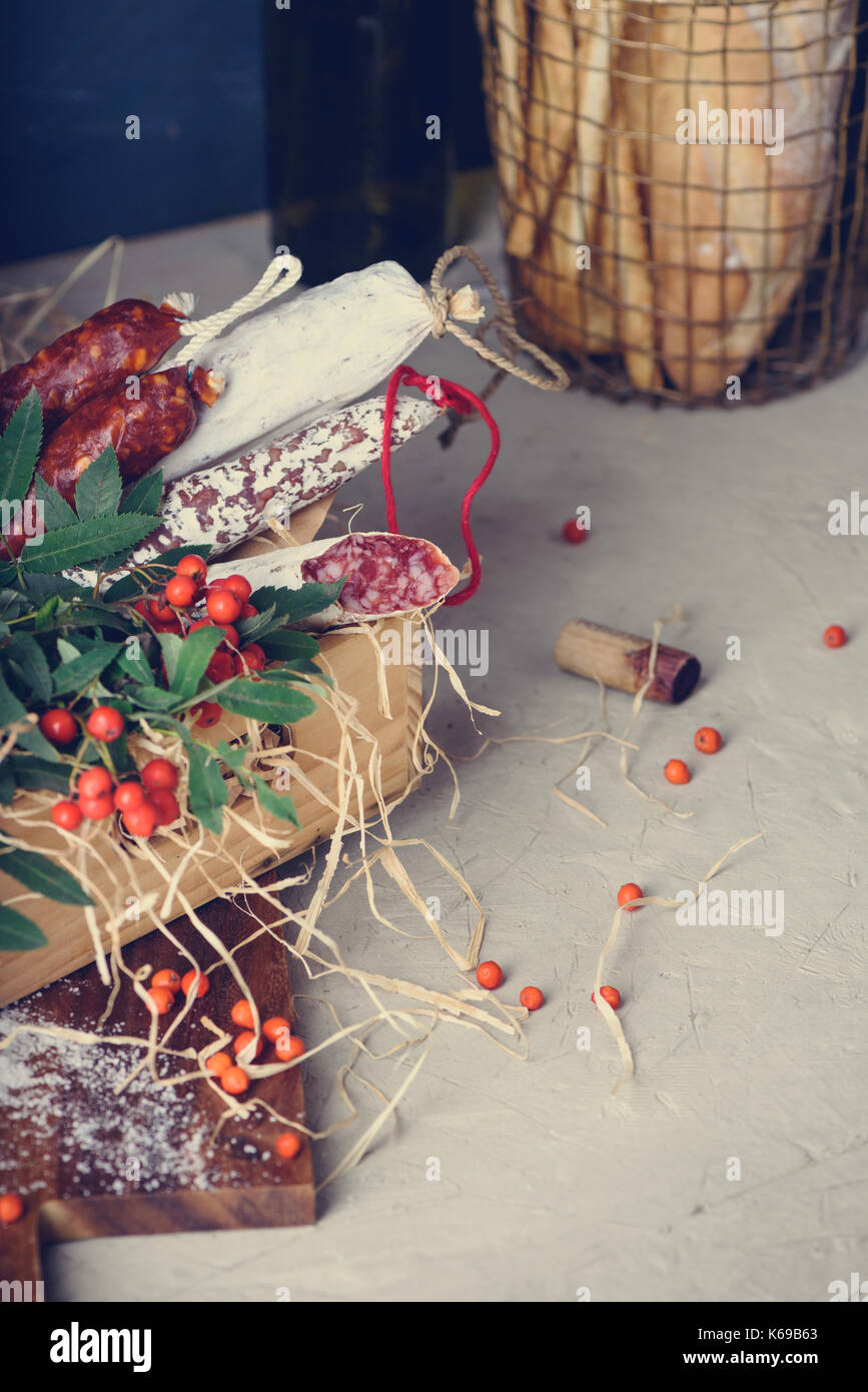 Cured meats, bread and berries appetizer on a cutting board. Fall ...