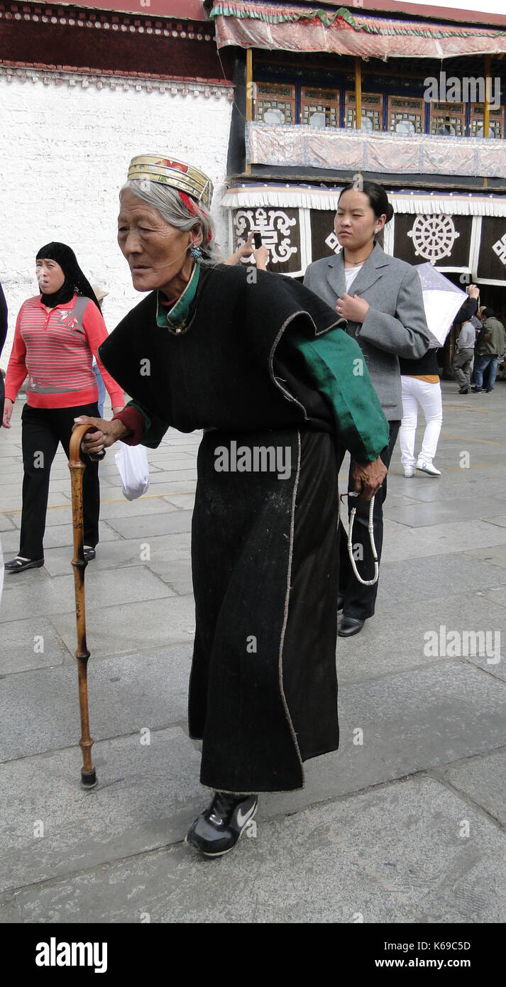 Tibet, China - Sep 7, 2012. An old woman walking at Jokhang Temple in ...