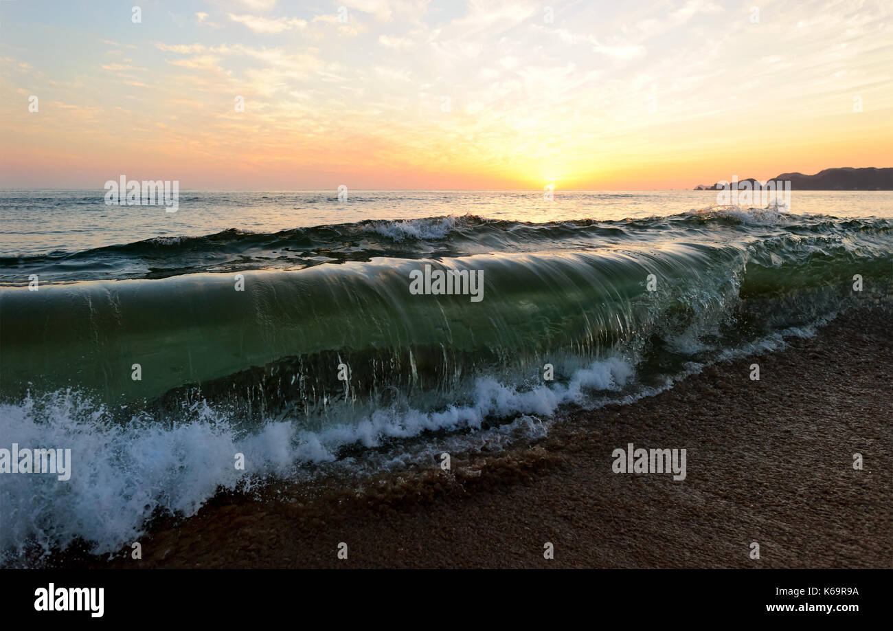 Ocean sunset wave breaking is a wave breaking on the beach as the sun ...