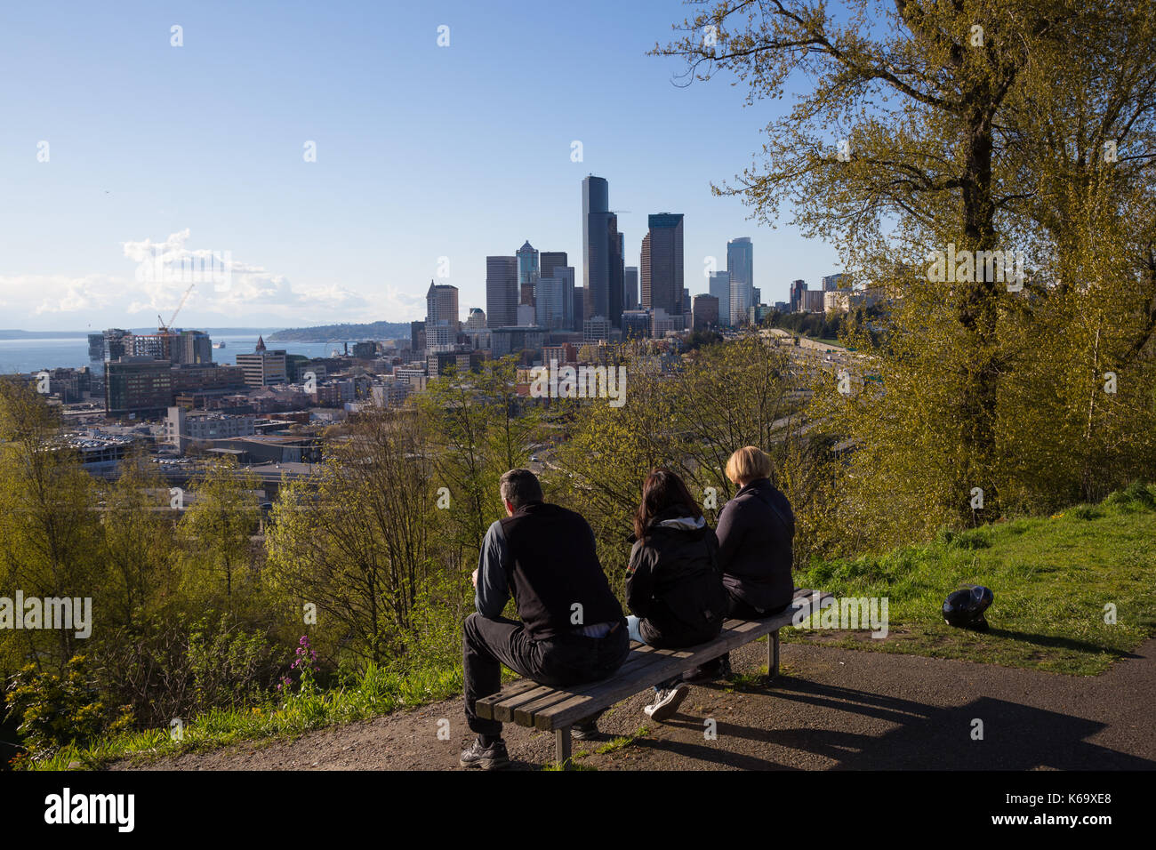 People relaxing on a bench with Downtown Seattle City Skyline in the ...