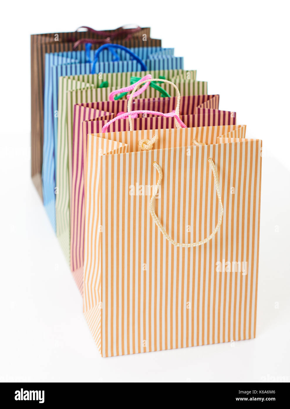 colorful striped shopping bags arranged in a row, object isolated on ...