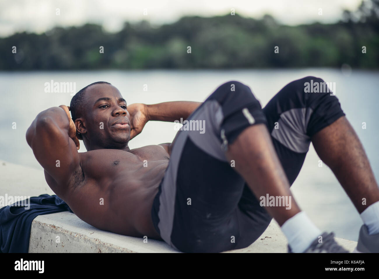 African athlete runner doing sit ups outdoor Stock Photo - Alamy
