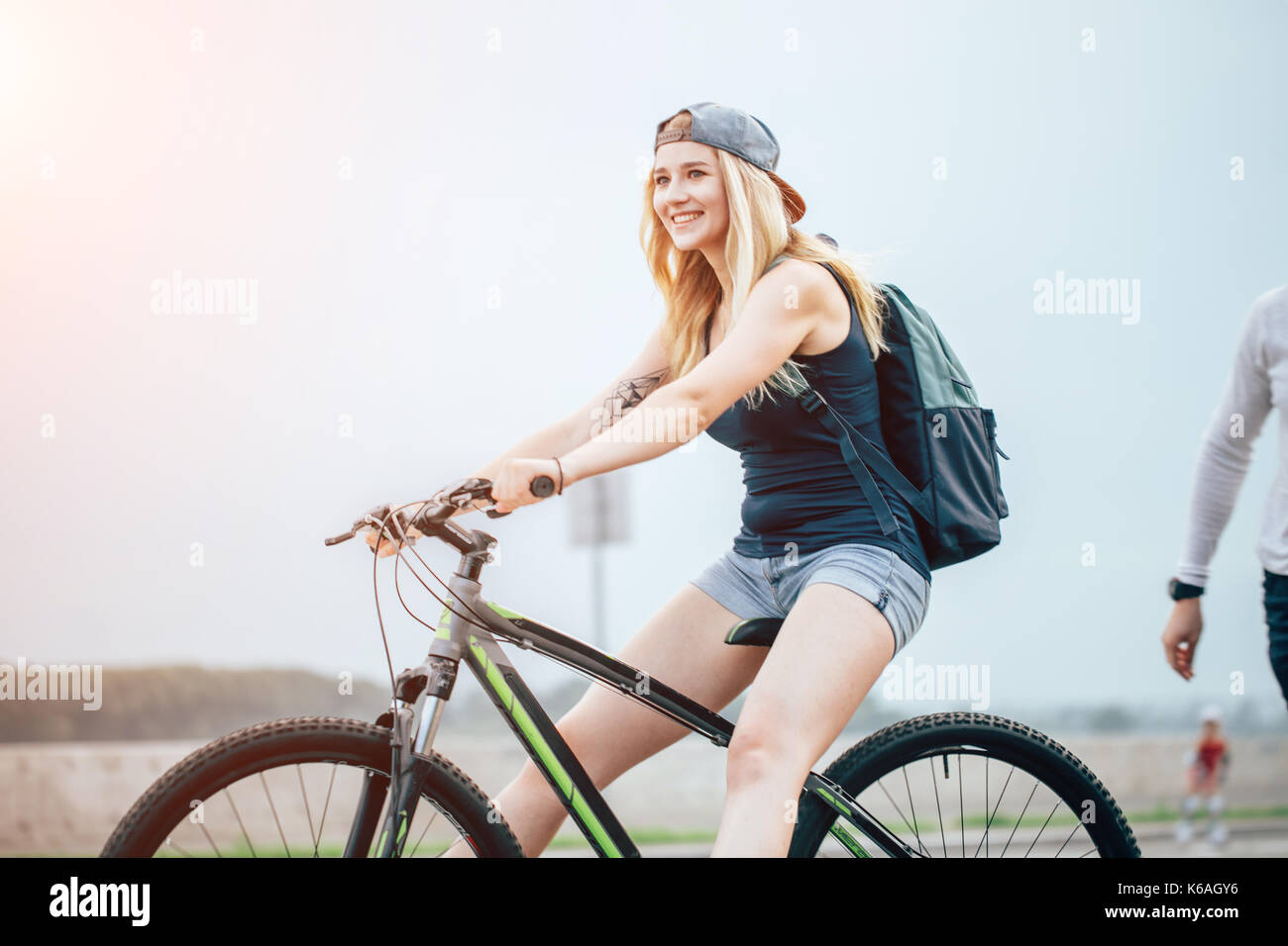 Side view portrait of a young beautiful woman riding on bicycle in city ...