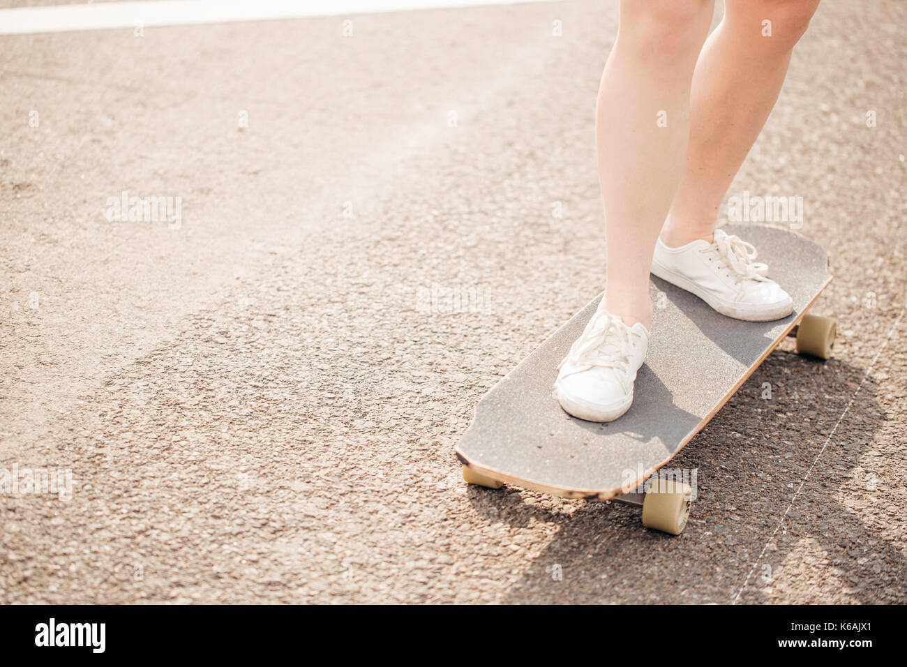 lifestyle, longboarding and people concept - female legs riding on ...