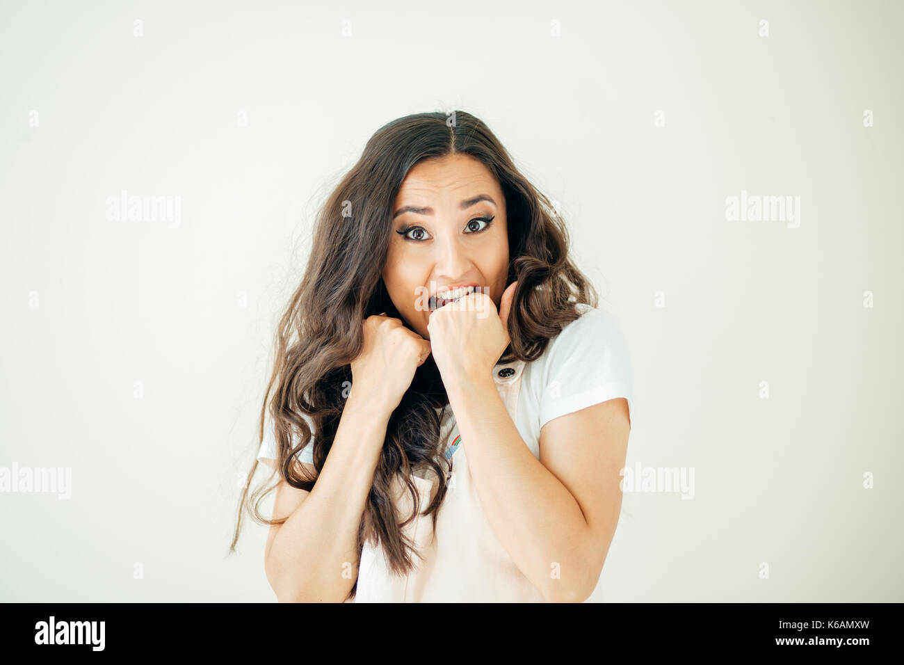 Surprised young woman shouting over white background. Looking at camera ...