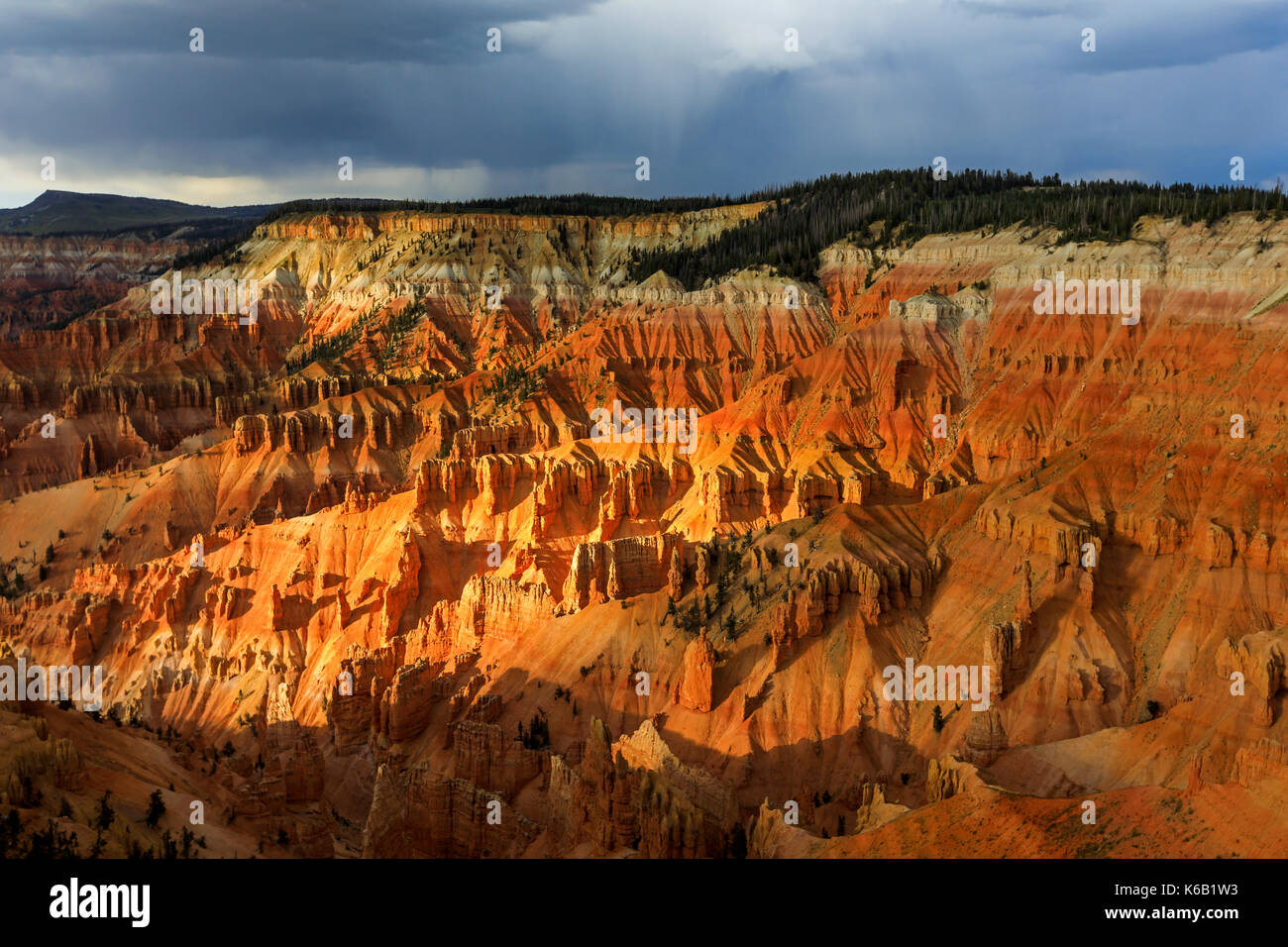 In this shot the sun spotlights the red rock formations in the ...