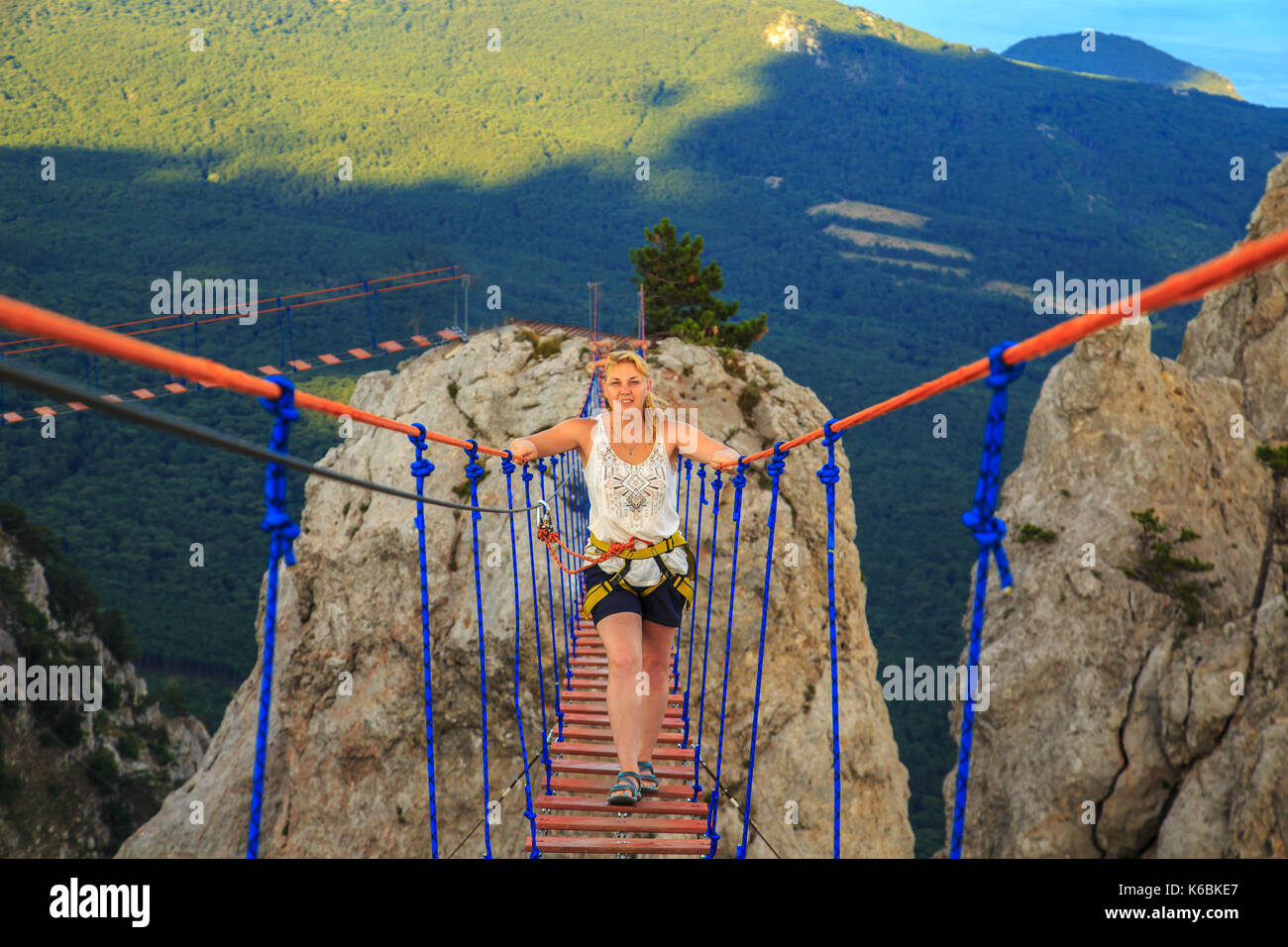Woman is walking along a suspension bridge over an abyss. Yalta, the ...