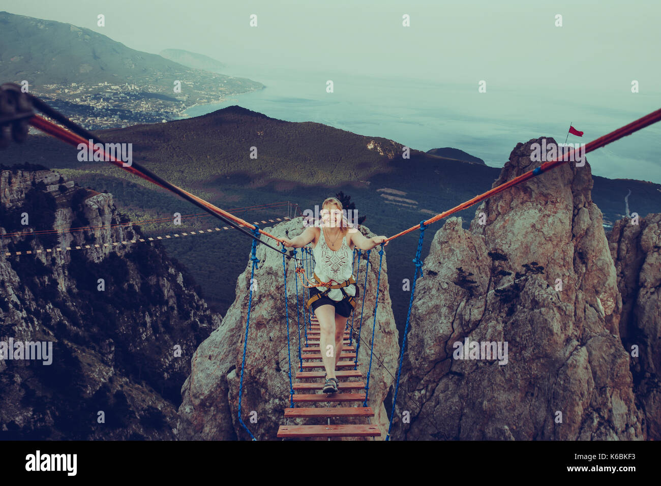 Woman is walking along a suspension bridge over an abyss. Yalta, the ...