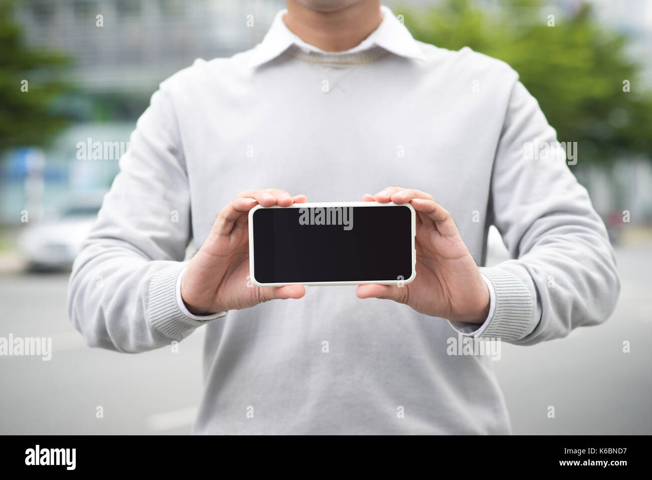 Business man holding and showing screen of smart phone Stock Photo - Alamy