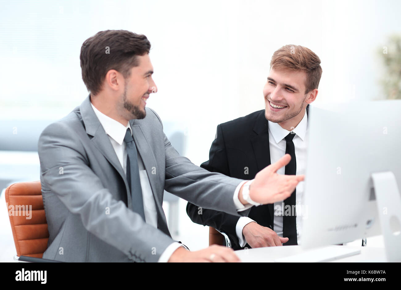 employees are talking sitting behind a Desk Stock Photo - Alamy