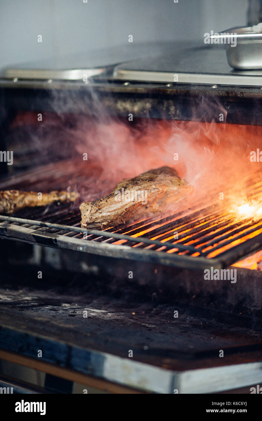 Tasty Beef steaks on the grill with fire flames Stock Photo - Alamy