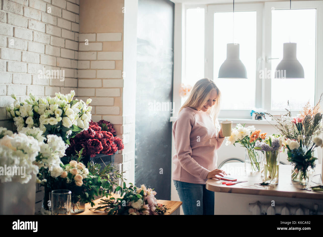 Florist at work. A woman in the process of making a summer bouquet of ...