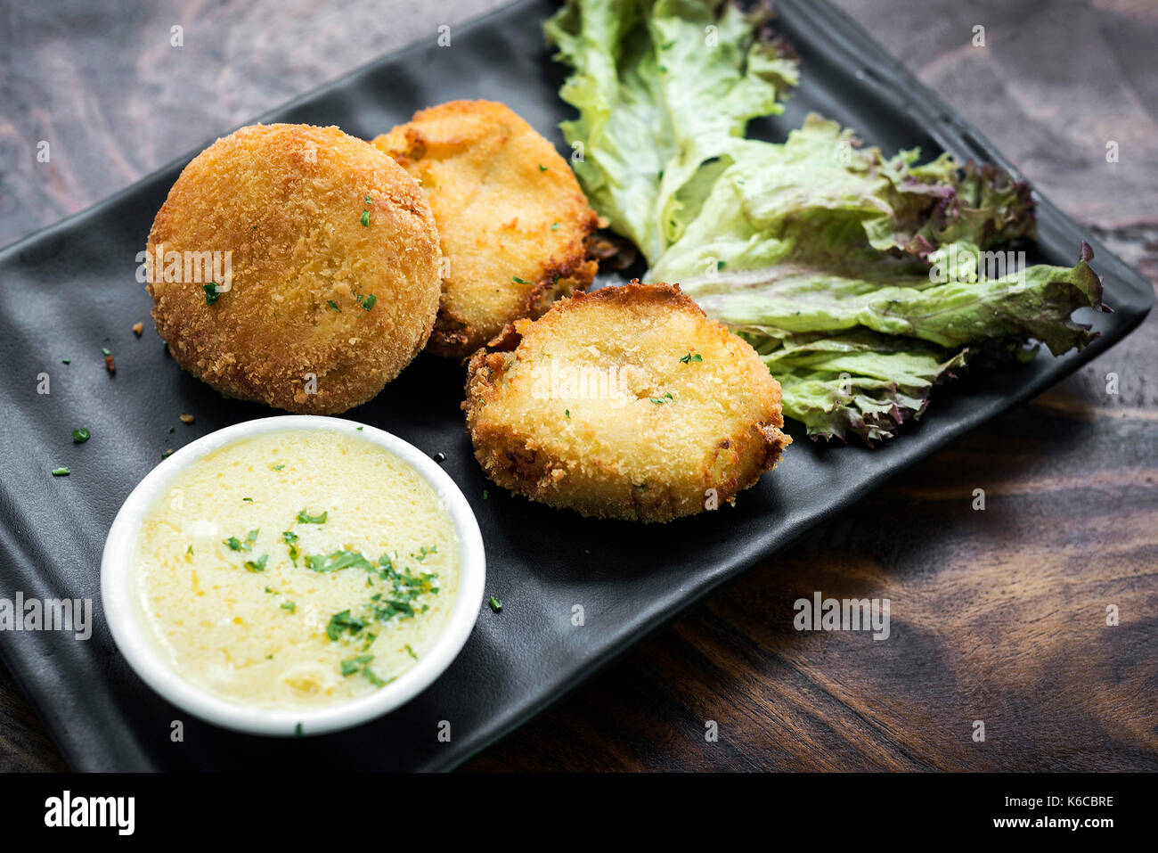 fried fish cakes with creamy garlic butter sauce snack Stock Photo - Alamy