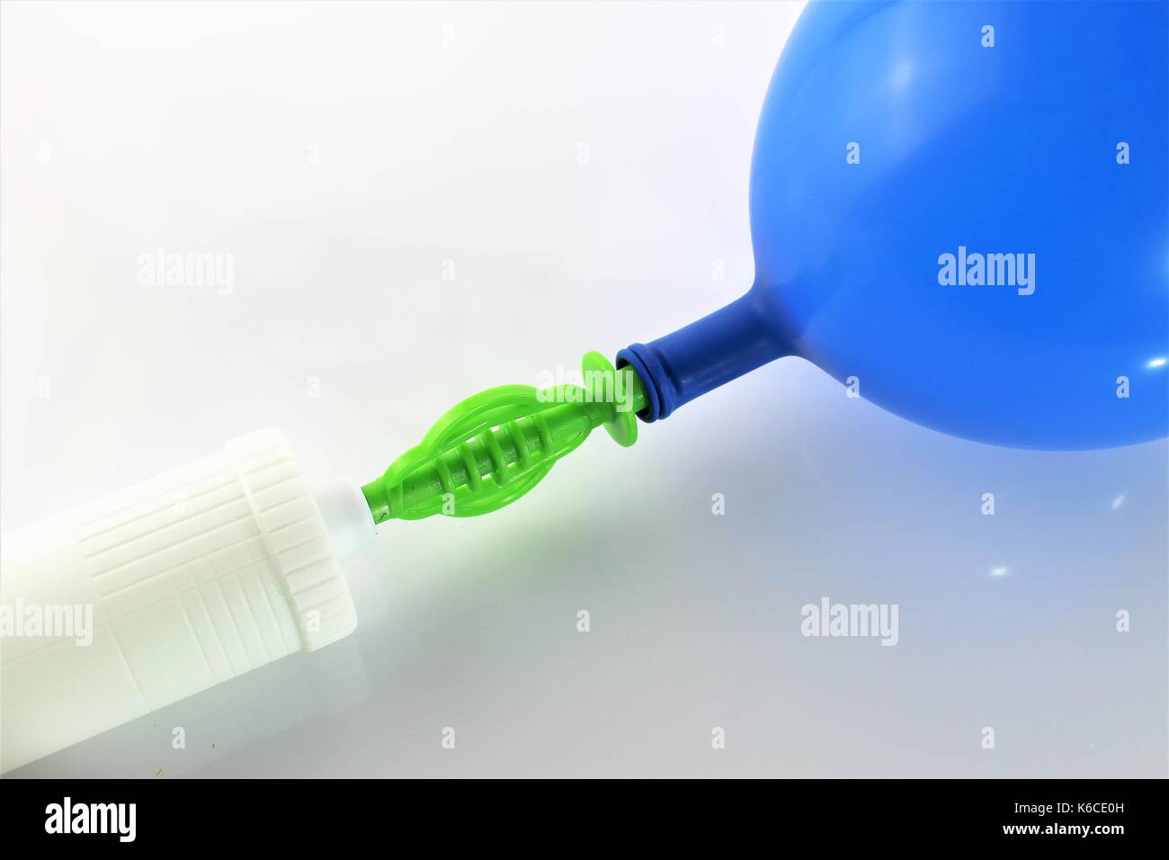 An image of a white air-pump inflating a blue balloon on a white ...