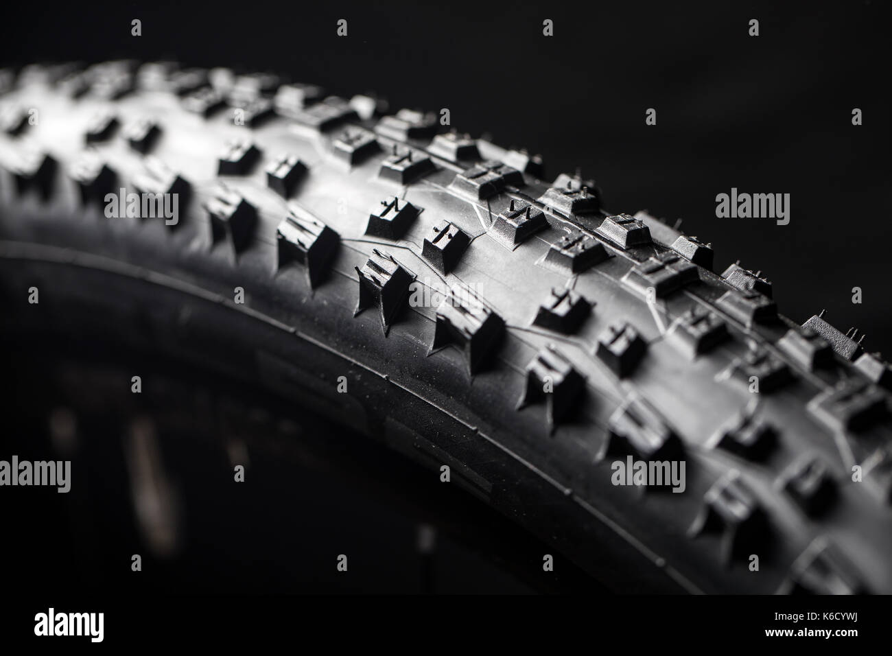 Modern MTB race mountain bike tyre isolated on black background in a ...