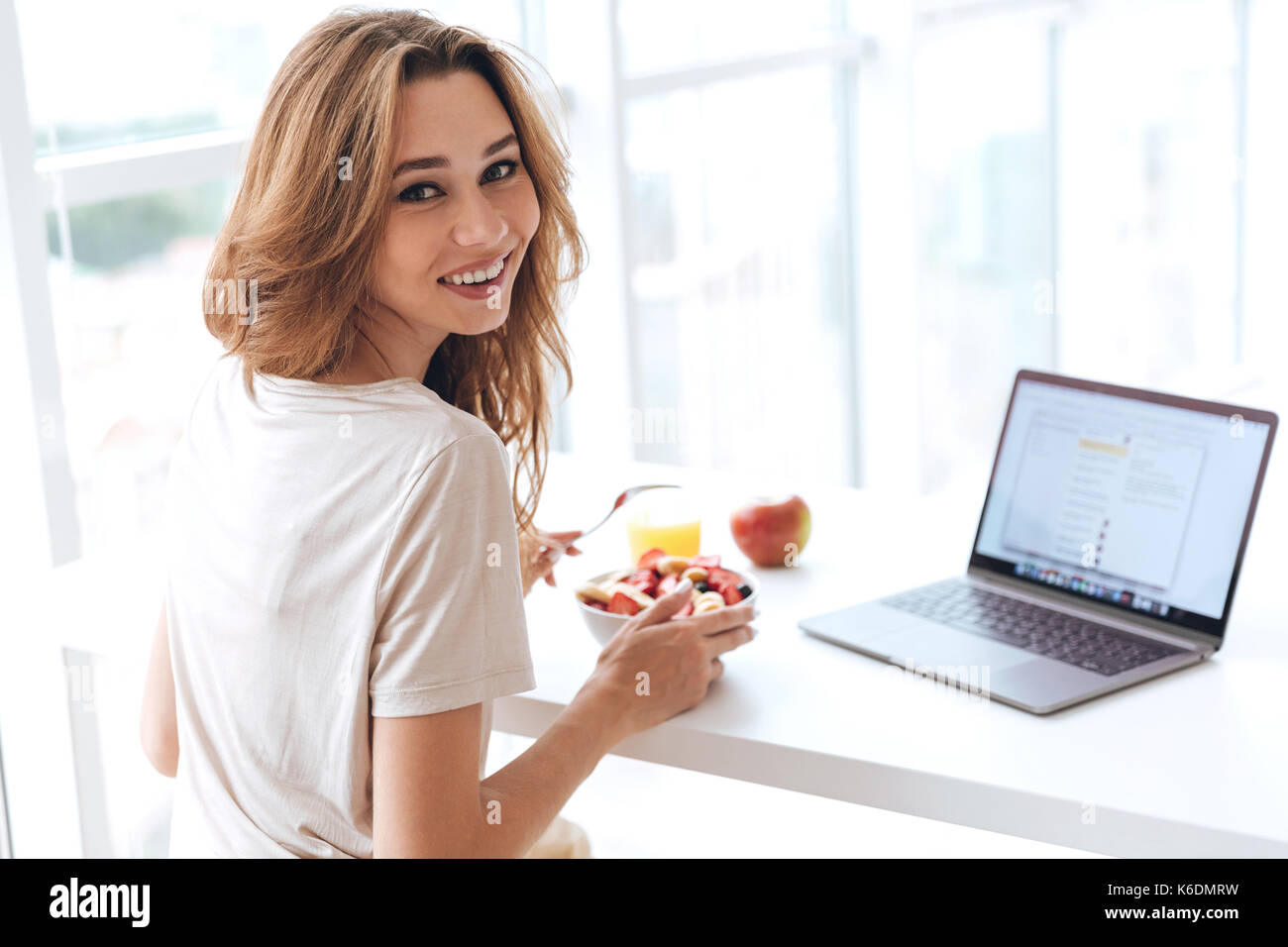 Back view of young cheerful woman looking camera and smiling while ...