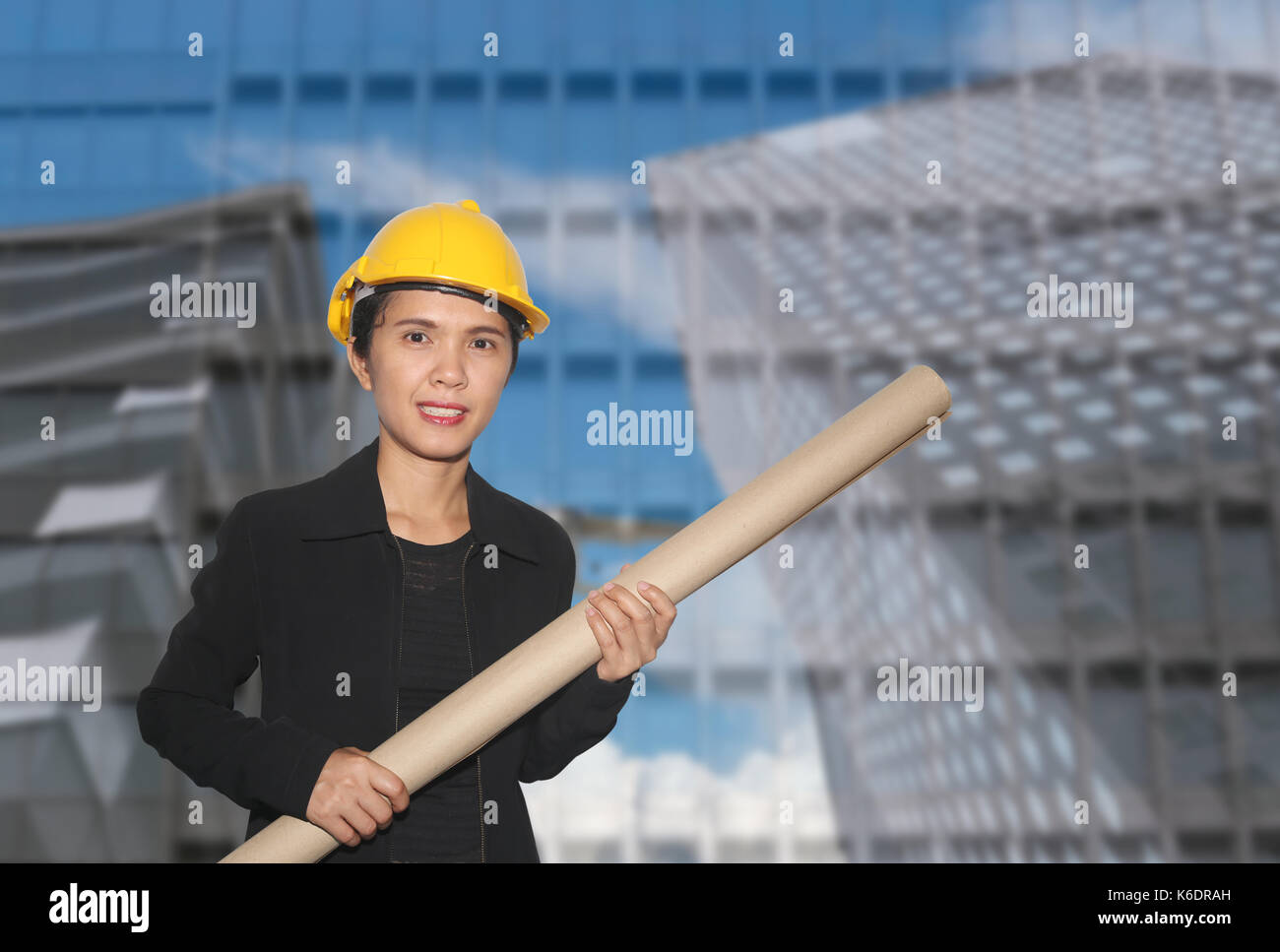 Asian female engineer and hold paper roll in hand on Skyscraper ...
