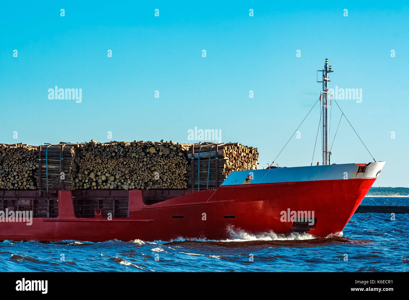 Red cargo ship fully loaded with wood moving at clear day Stock Photo ...