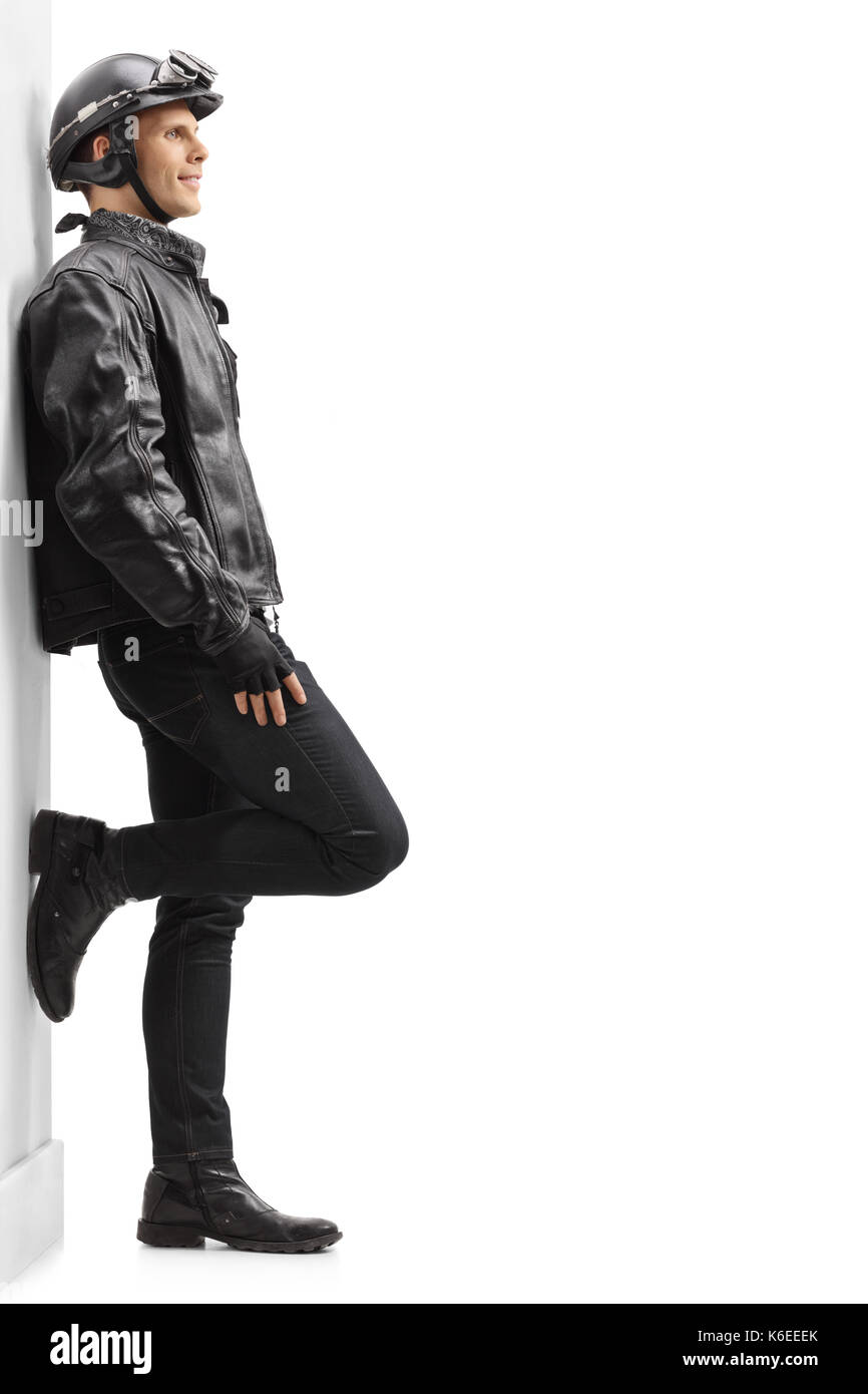 Full length profile shot of a biker leaning against wall isolated on ...