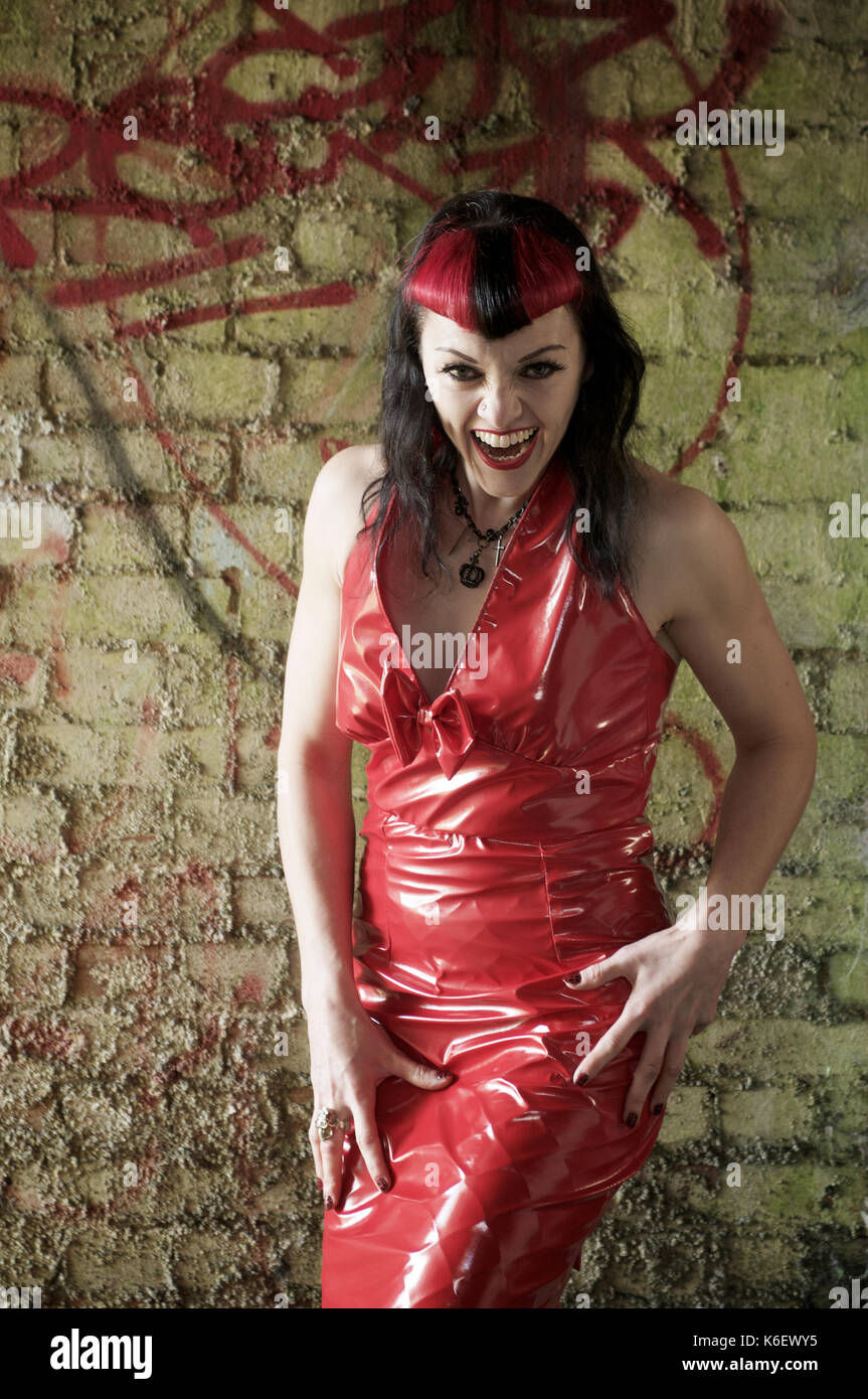 Burlesque performer wearing a red shiny dress in an interior location ...