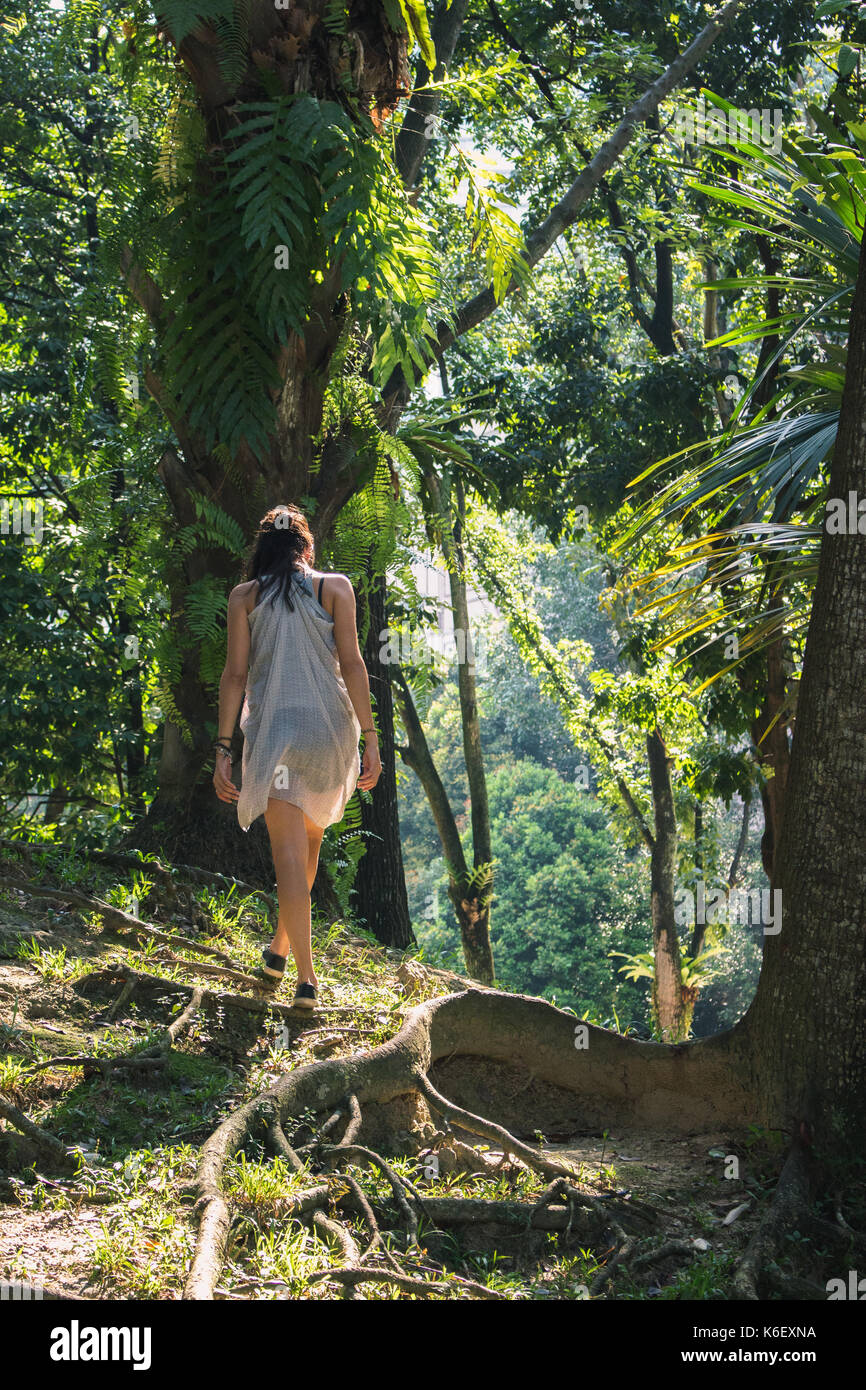 Young girl walking into the bushes of Kuala Lumpur central park Stock ...