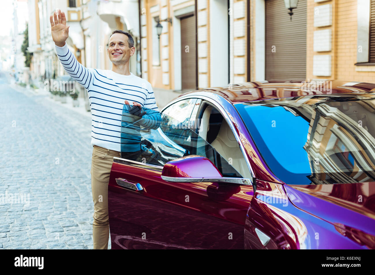 Positive nice man saying good bye to his friends Stock Photo - Alamy