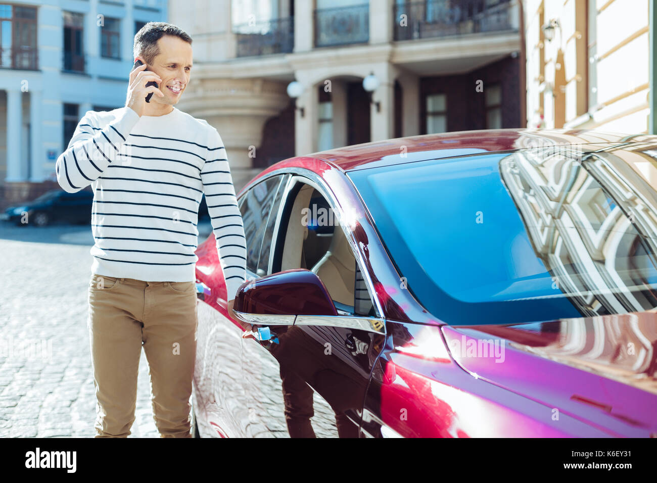 Positive good looking man getting into his car Stock Photo - Alamy