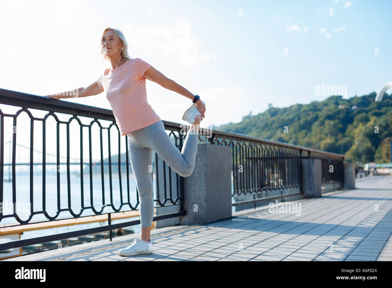 Athletic woman stretching her leg on the bridge Stock Photo - Alamy
