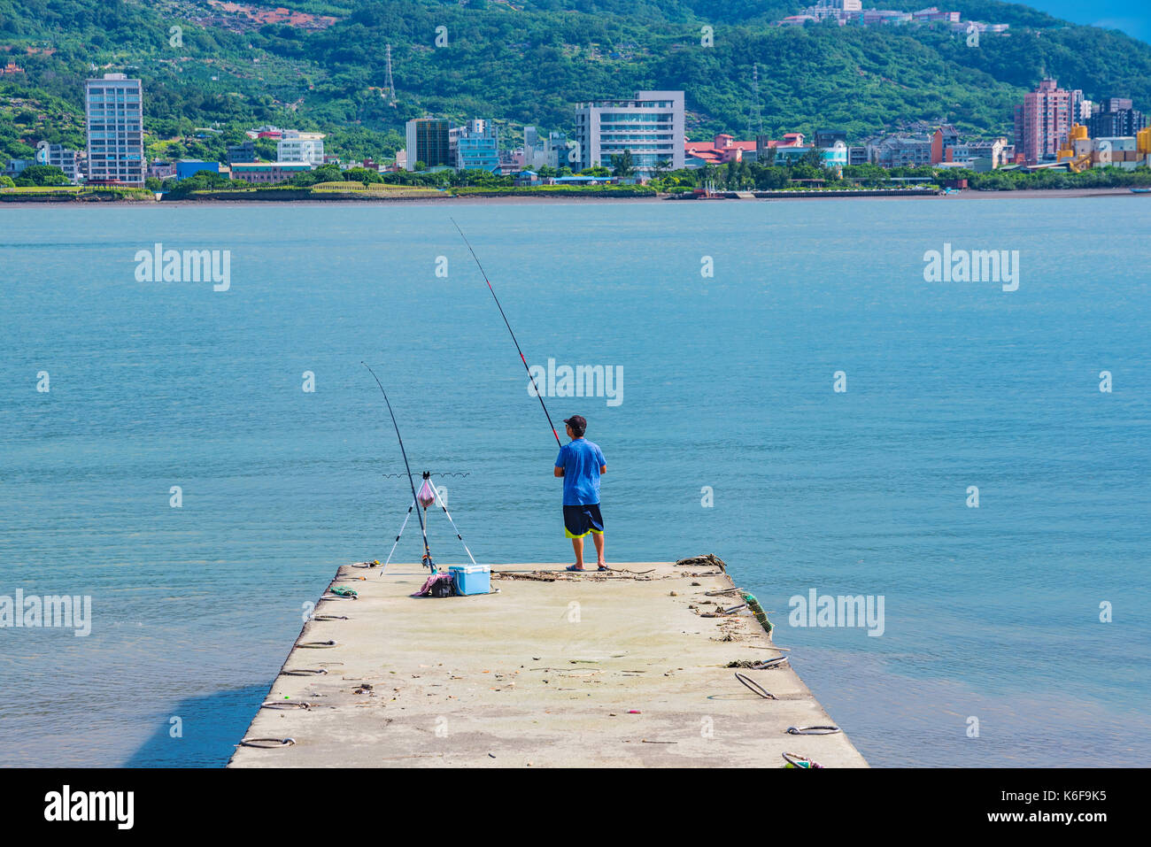 Fisherman fishing on a pier in Taiwan Stock Photo - Alamy