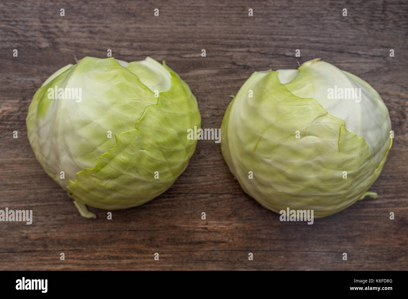 Cabbage two cabbages lie on brown wood Stock Photo - Alamy