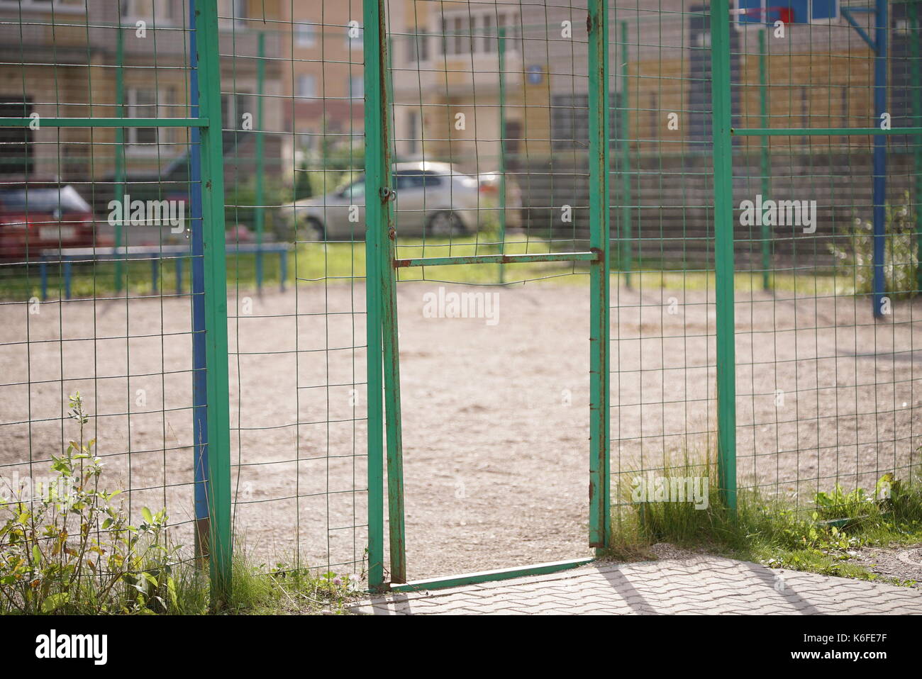 Broken steel mesh of metal fence of a basketball court in residential ...