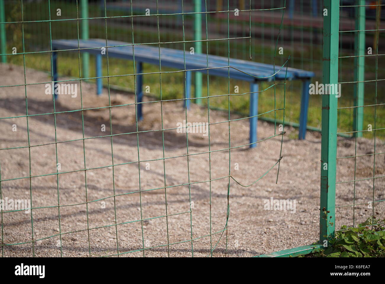 Broken steel mesh of metal fence of a basketball court in residential ...