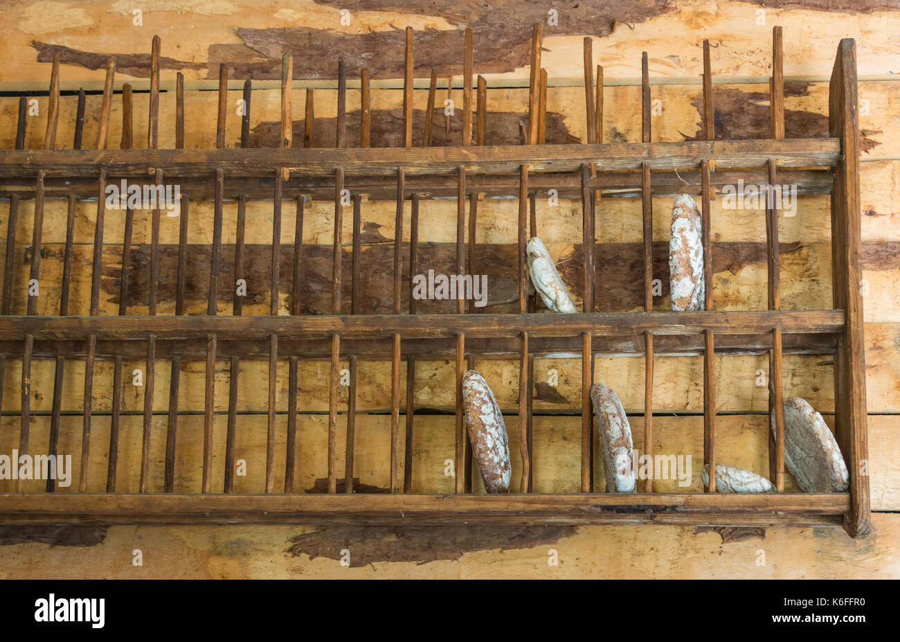 homemade rustic bread in the wall bracket hanging from the wooden wall ...
