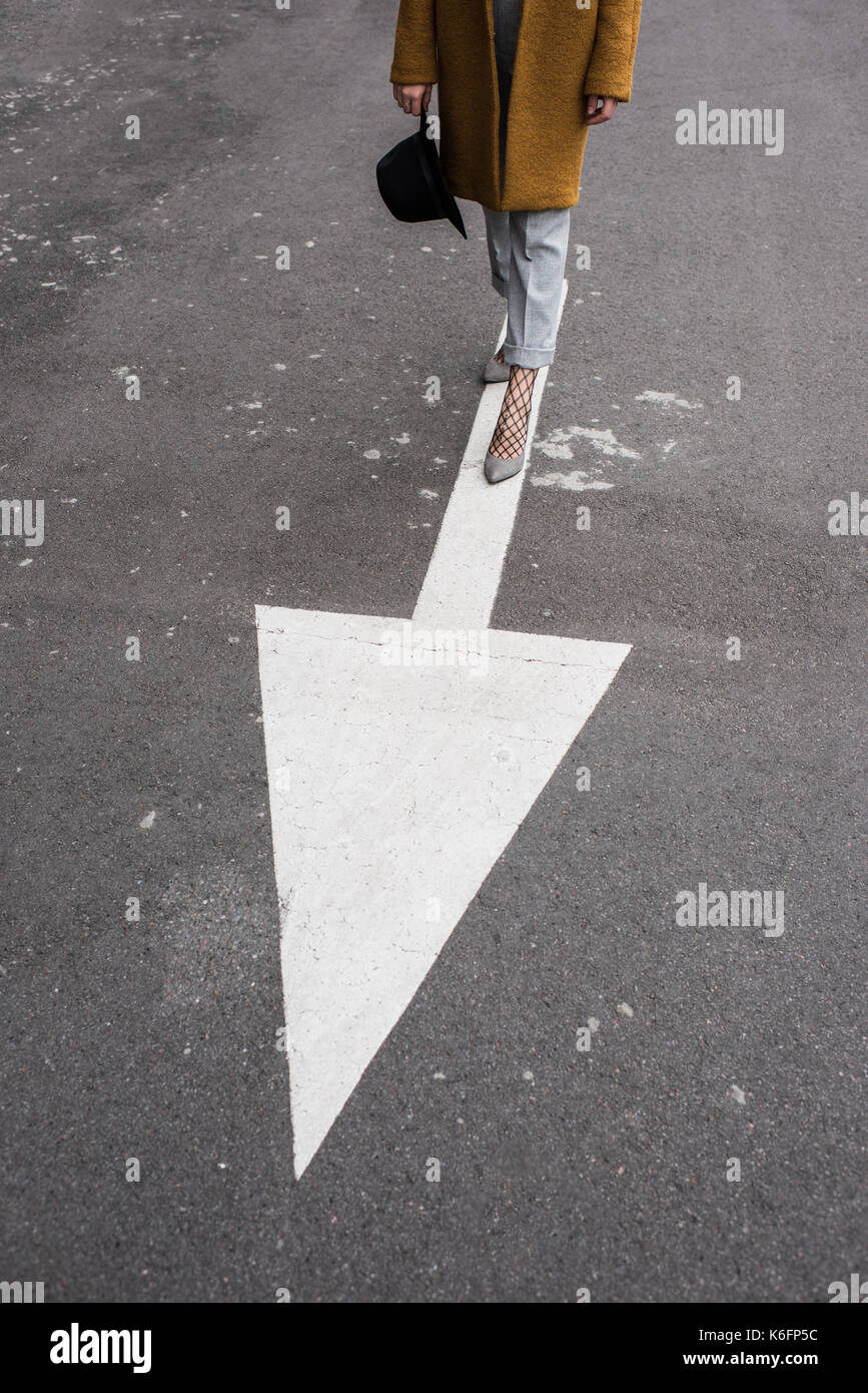 woman standing on arrow sign Stock Photo - Alamy