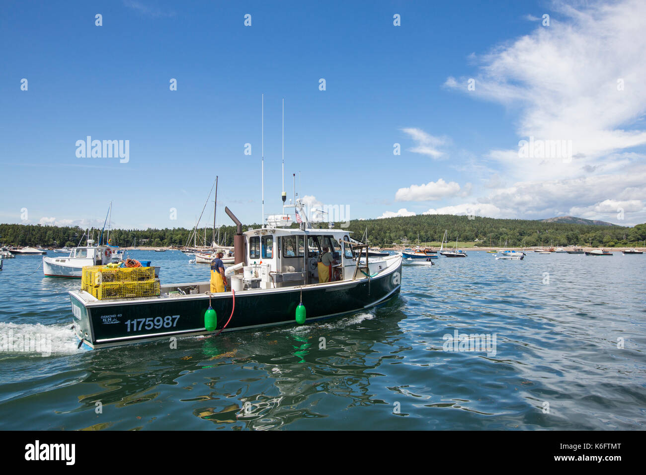 Fishing boat with fishermen pulling into port near Acadia National Park ...