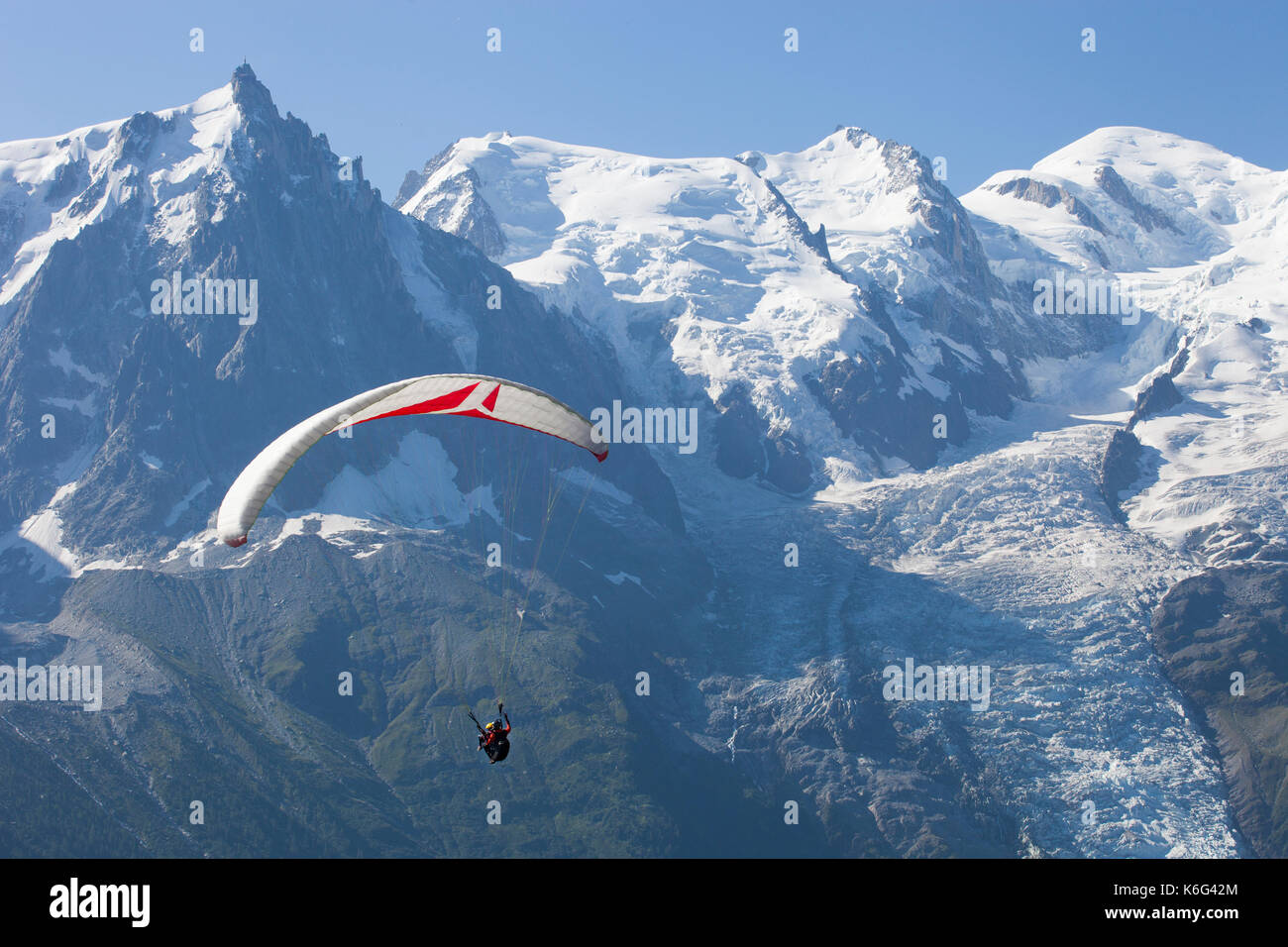 Paraglider flying above valley of Chamonix with spectacular views on Mont Blanc range, Chamonix ...