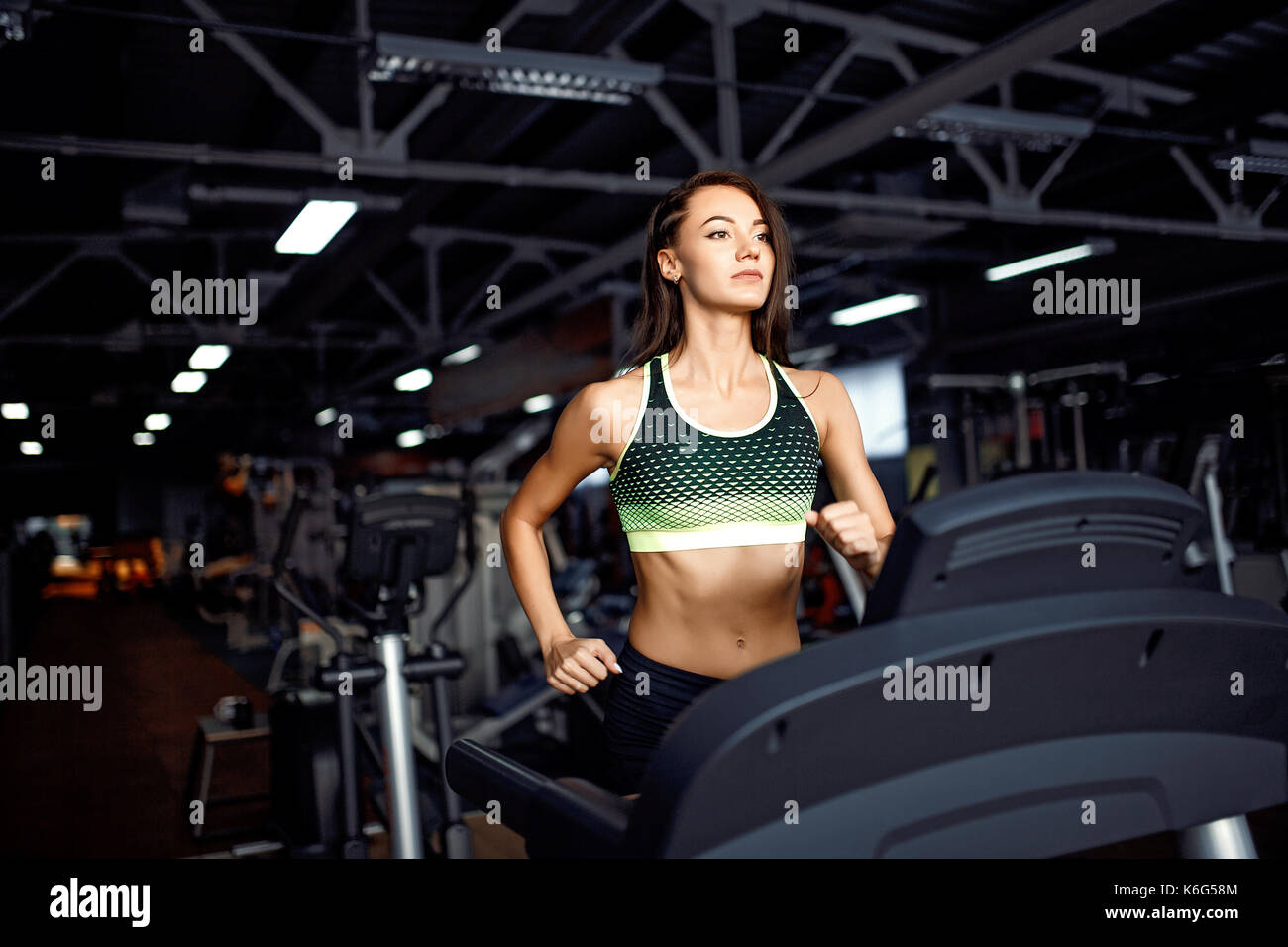 Young fitness woman doing cardio exercises at the gym running on a ...